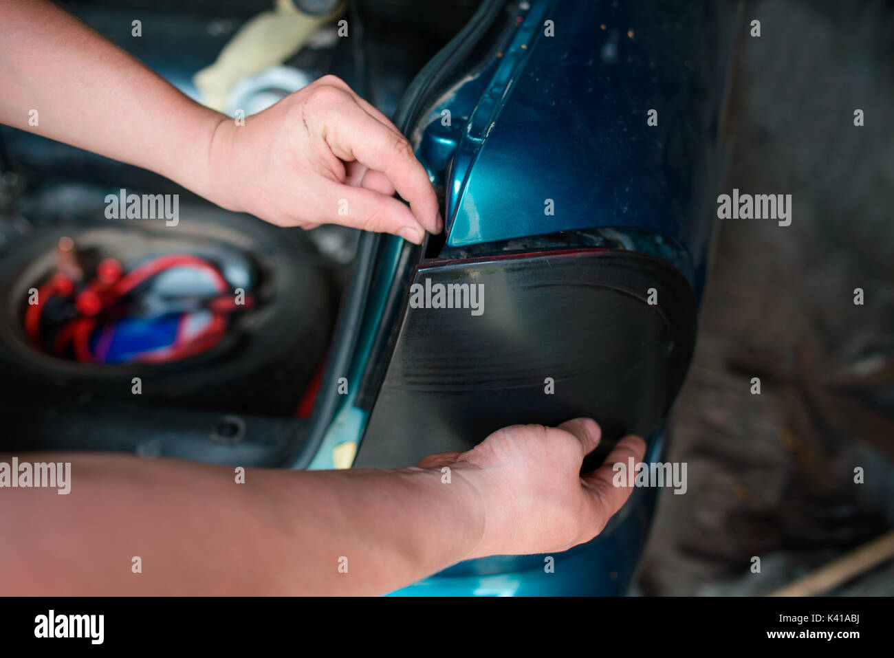 Closeup repairing of an broken blue car in garage by hands of machanic ...