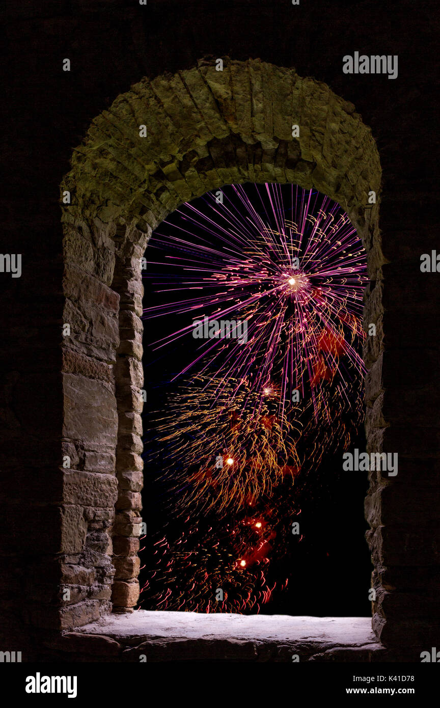 Firework flashes on the dark night sky background with an old ancient ...