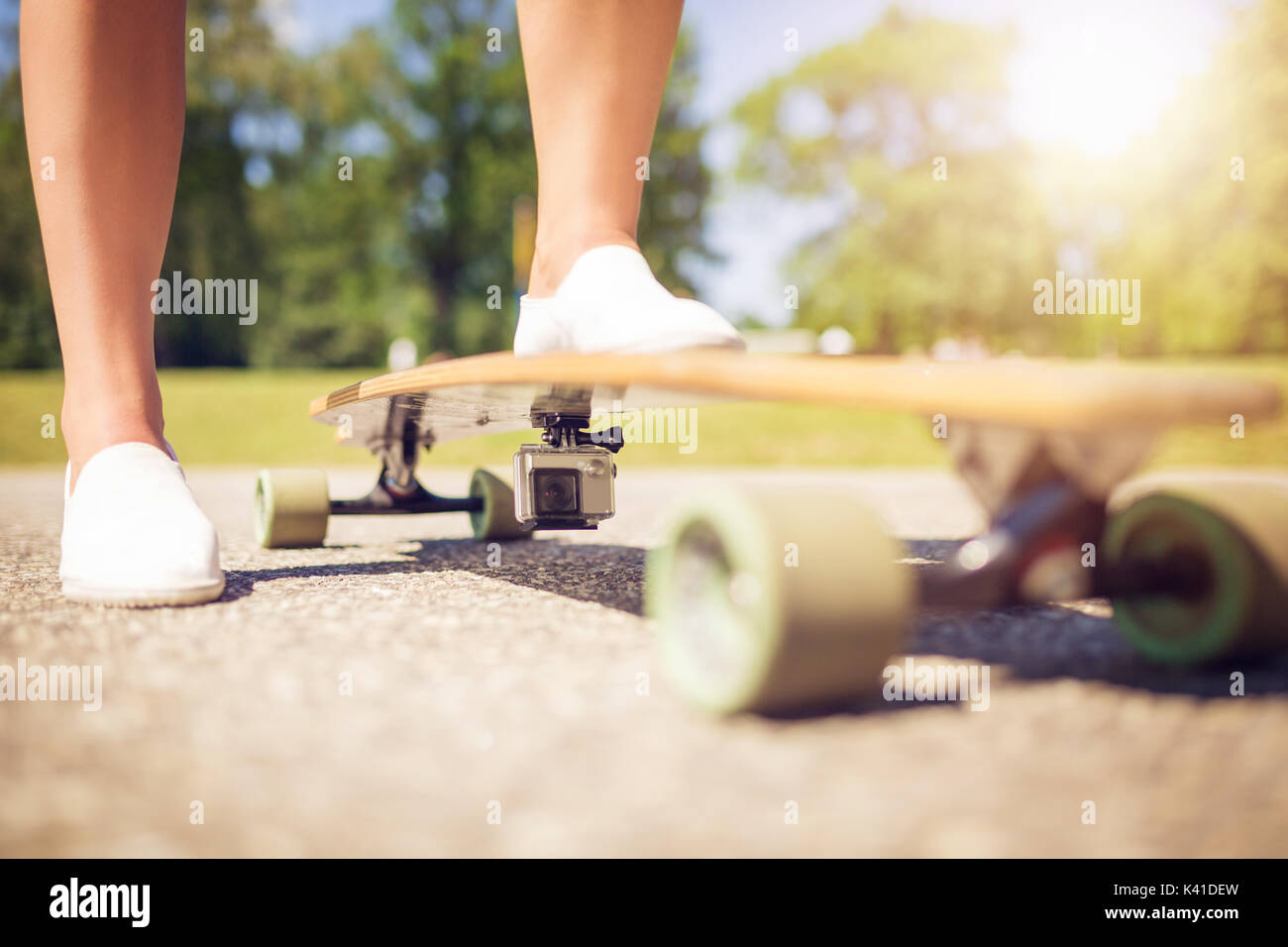 A photo of longboard with action camera installed on. There's someone ...