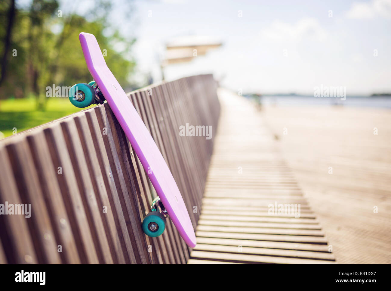 A photo of pink shortboard being attached on the bench at the seaside ...