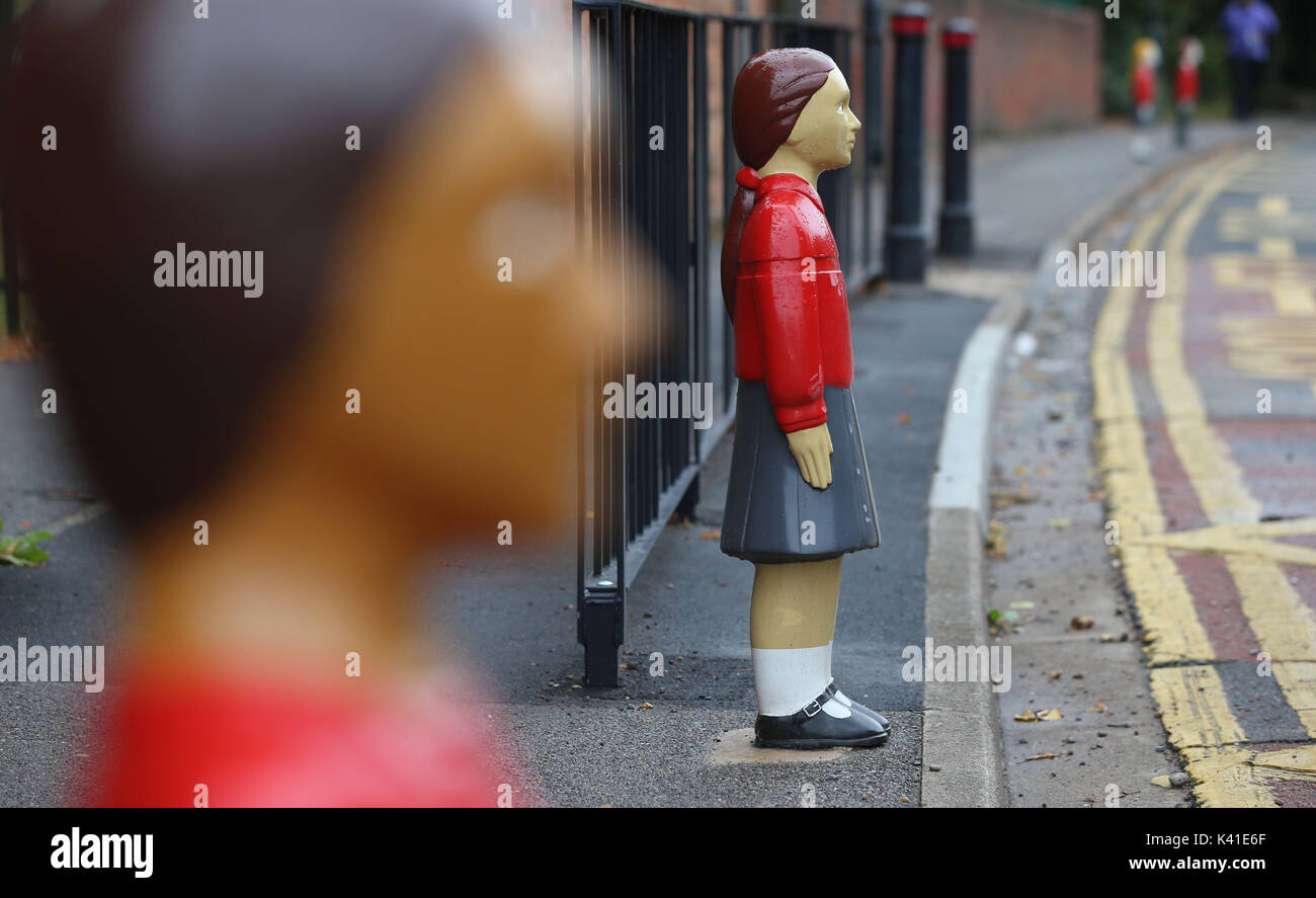 Bollards painted to resemble young children line the pavement close to ...