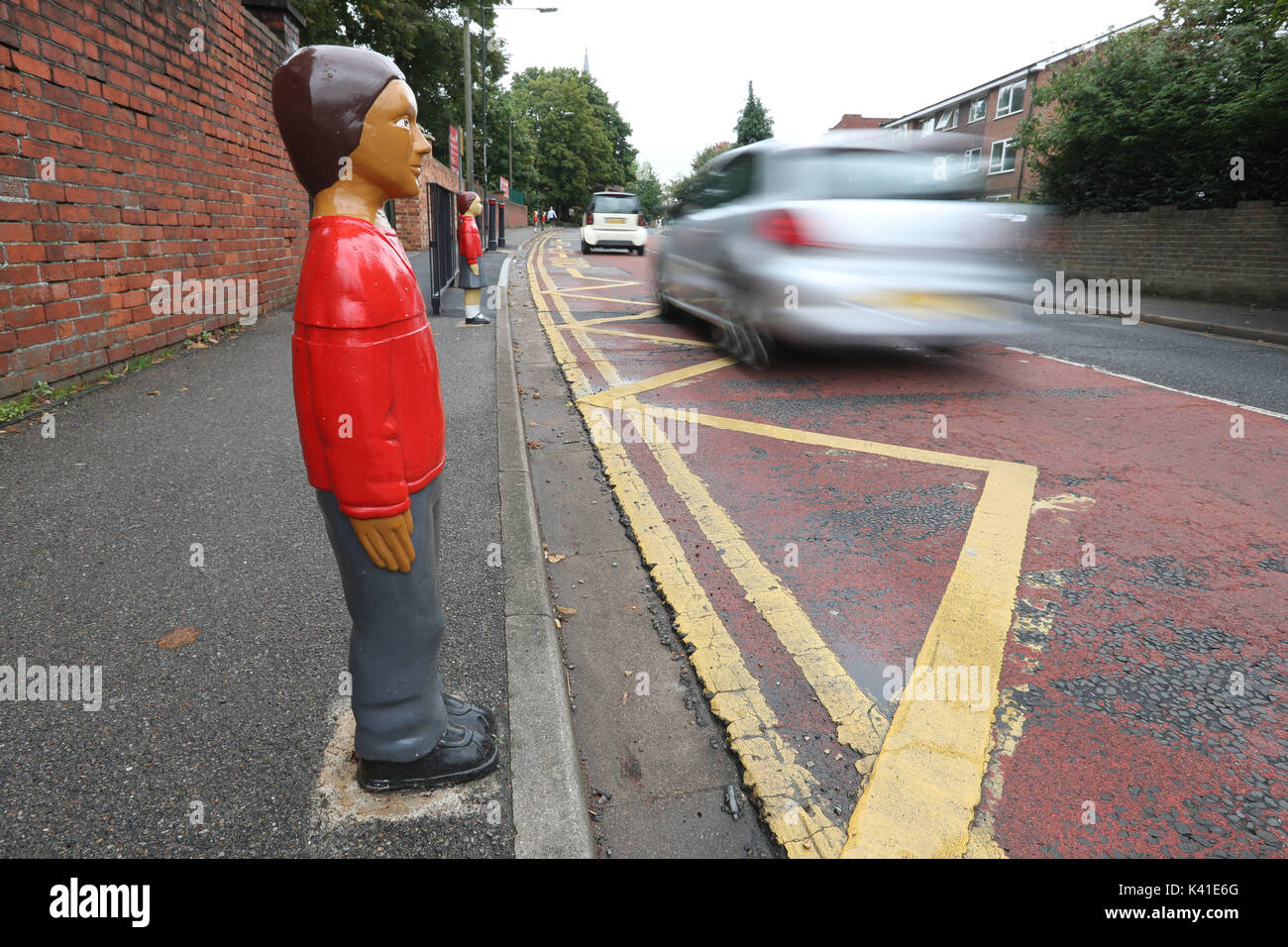 Bollards painted to resemble young children line the pavement close to ...