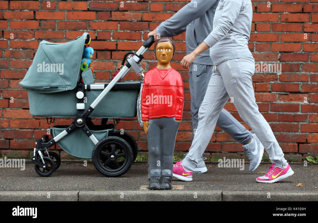 Bollards painted to resemble young children line the pavement close to ...