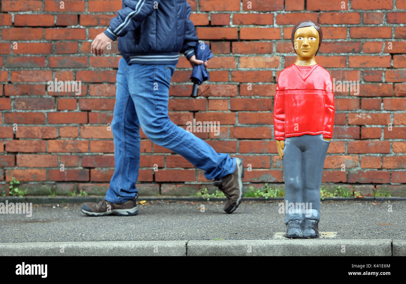 Bollards painted to resemble young children line the pavement close to ...