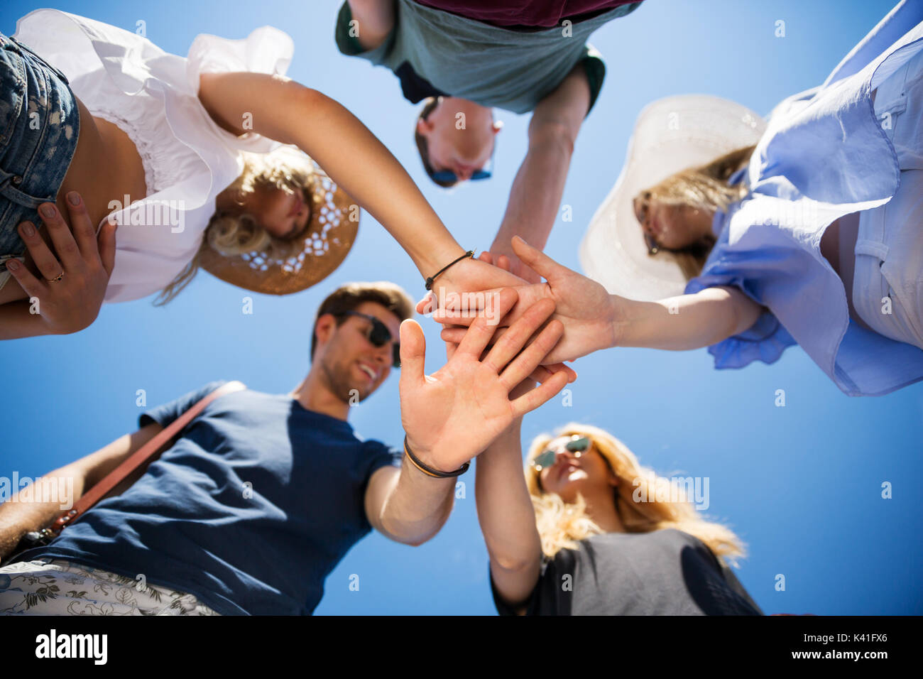 A photo of group of close friends standing in the circle and putting ...