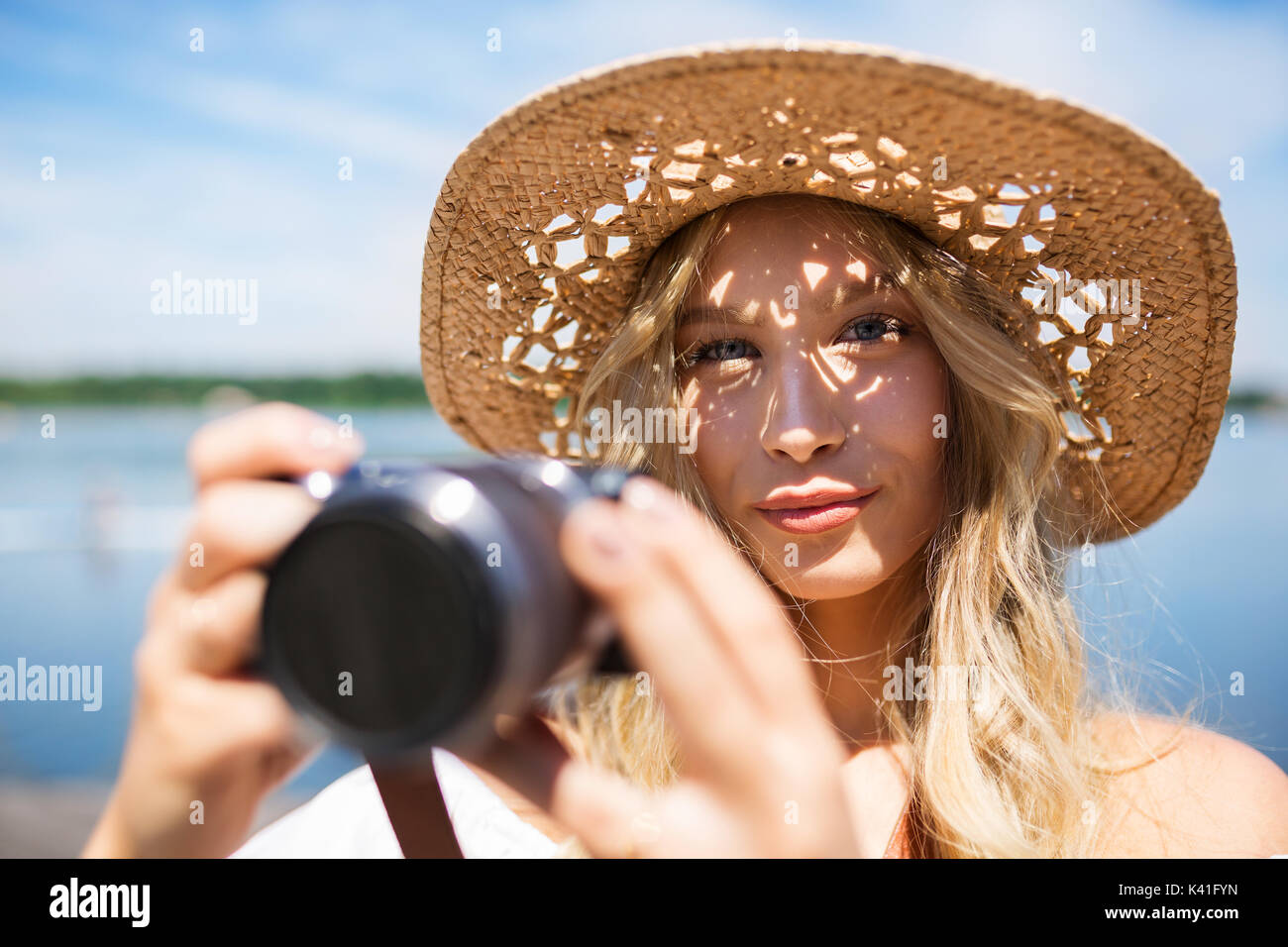A photo of young, beautiful woman taking a photo. She seems to be glad ...