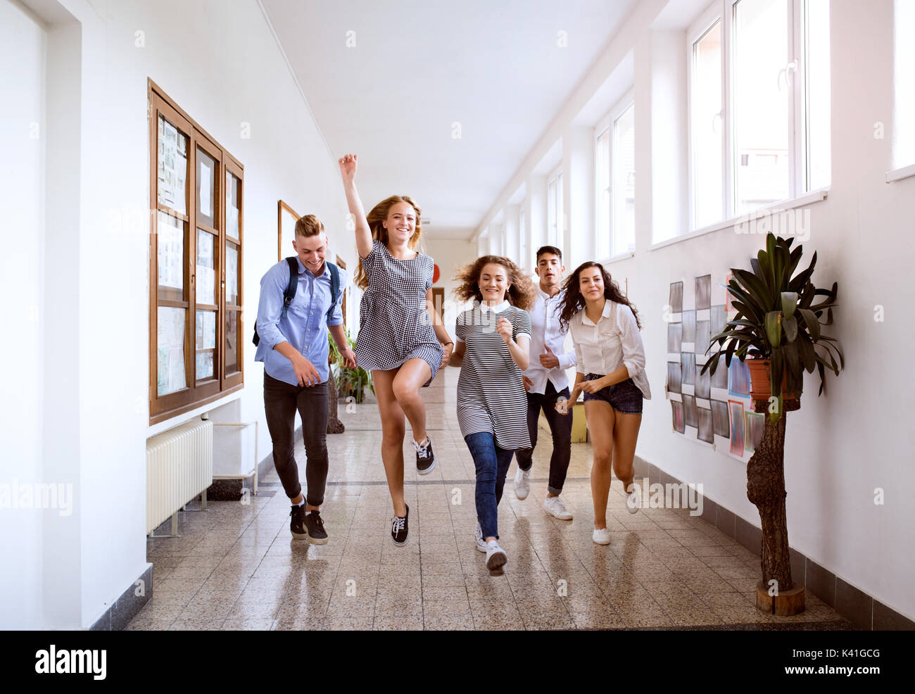 Teenage students in high school hall jumping high Stock Photo - Alamy