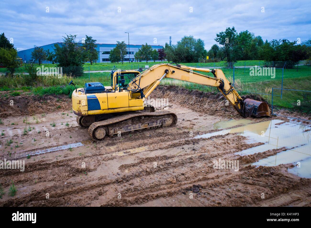Yellow excavator on the tracks in the mud Stock Photo - Alamy