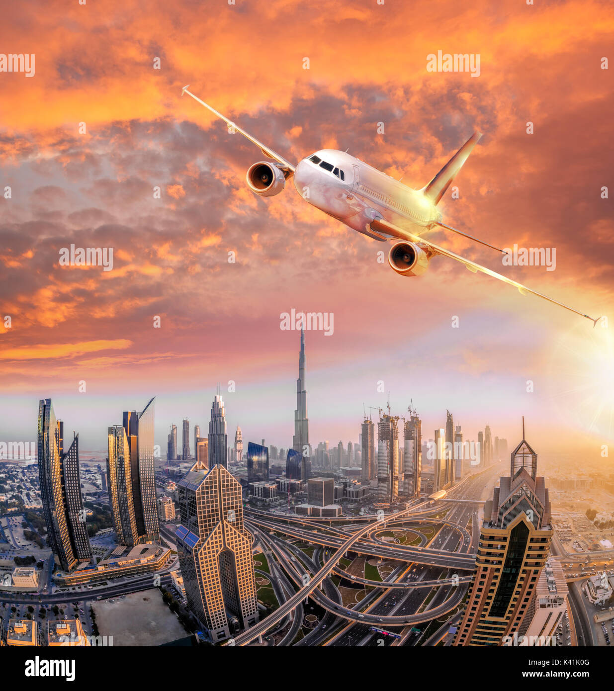 Airplane is flying over Dubai against colorful sunset in United Arab ...