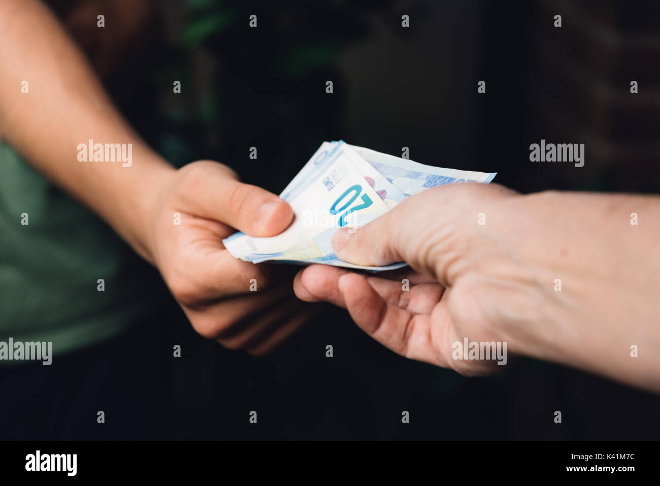 Hand of woman is giving euro money to a young man Stock Photo - Alamy