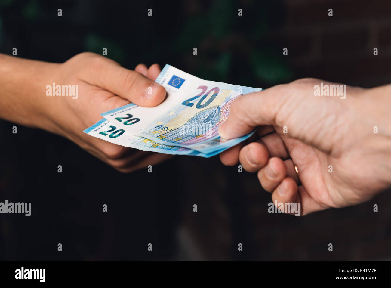 Hand of woman is giving euro money to a young man Stock Photo - Alamy