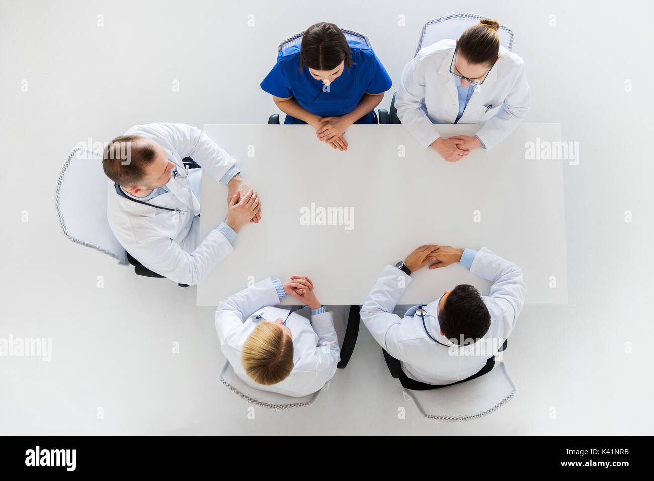 group of doctors sitting at empty table Stock Photo - Alamy