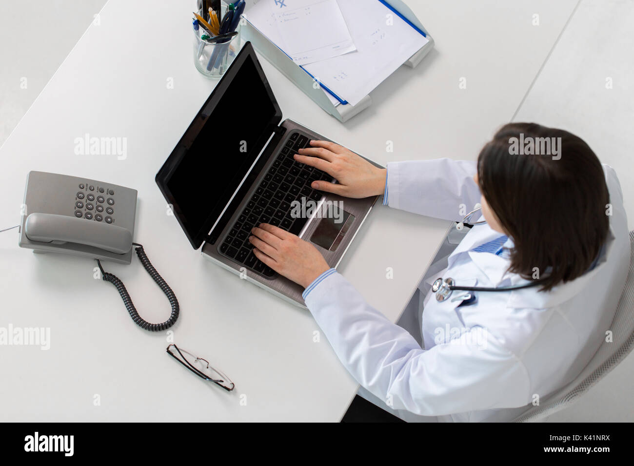 woman doctor typing on laptop at clinic Stock Photo - Alamy
