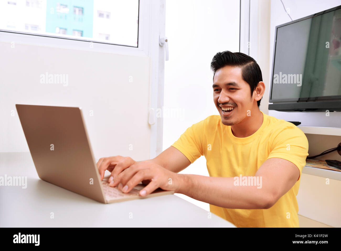 Happy asian man sitting hi-res stock photography and images - Alamy