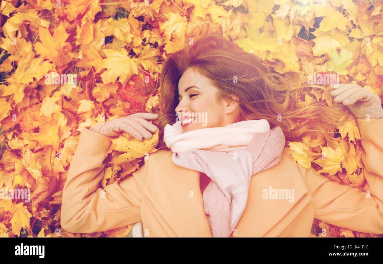 beautiful happy woman lying on autumn leaves Stock Photo - Alamy