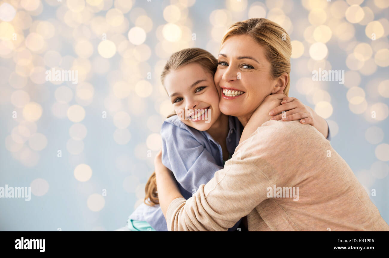 happy girl with mother hugging over lights Stock Photo - Alamy