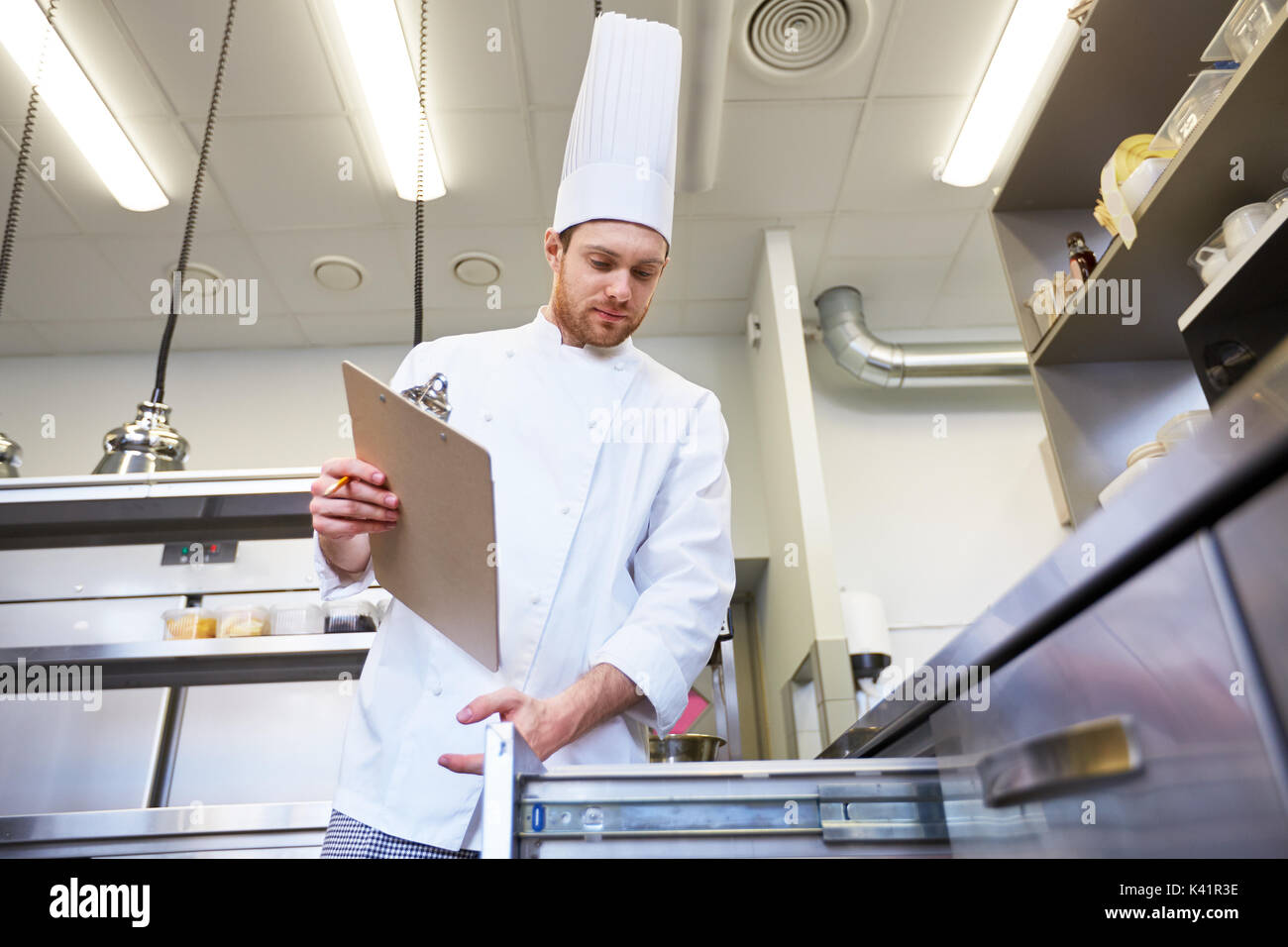 chef with clipboard doing inventory at kitchen Stock Photo - Alamy