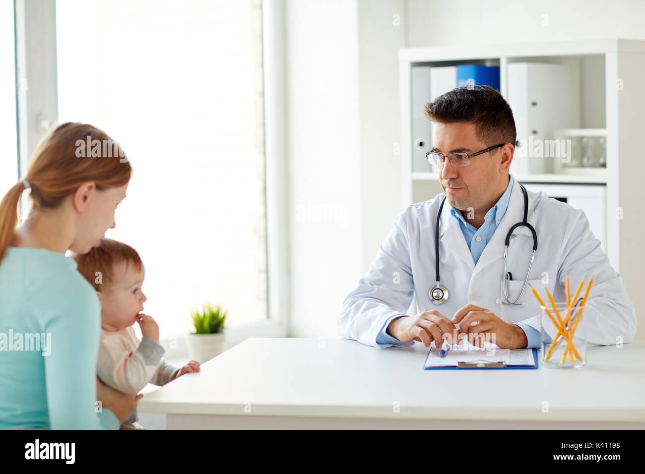 woman with baby and doctor at clinic Stock Photo - Alamy