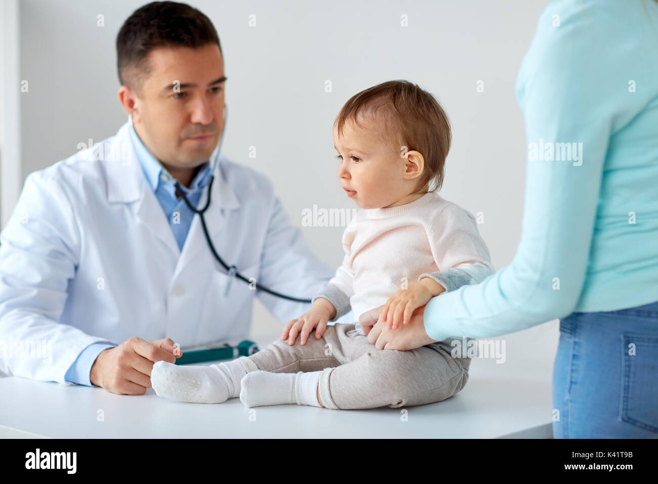 happy woman with baby and doctor at clinic Stock Photo - Alamy