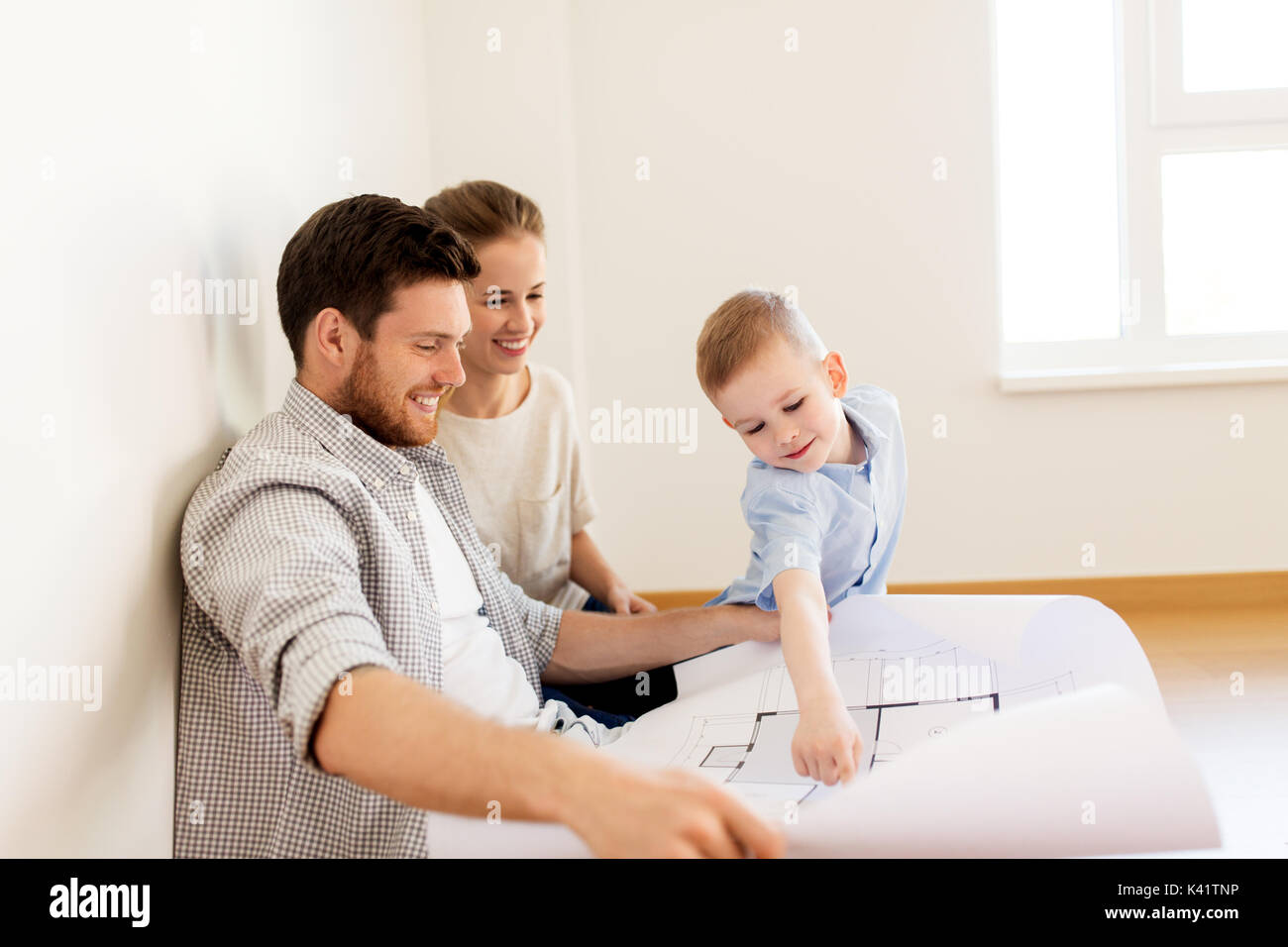 happy family with blueprint moving to new home Stock Photo - Alamy