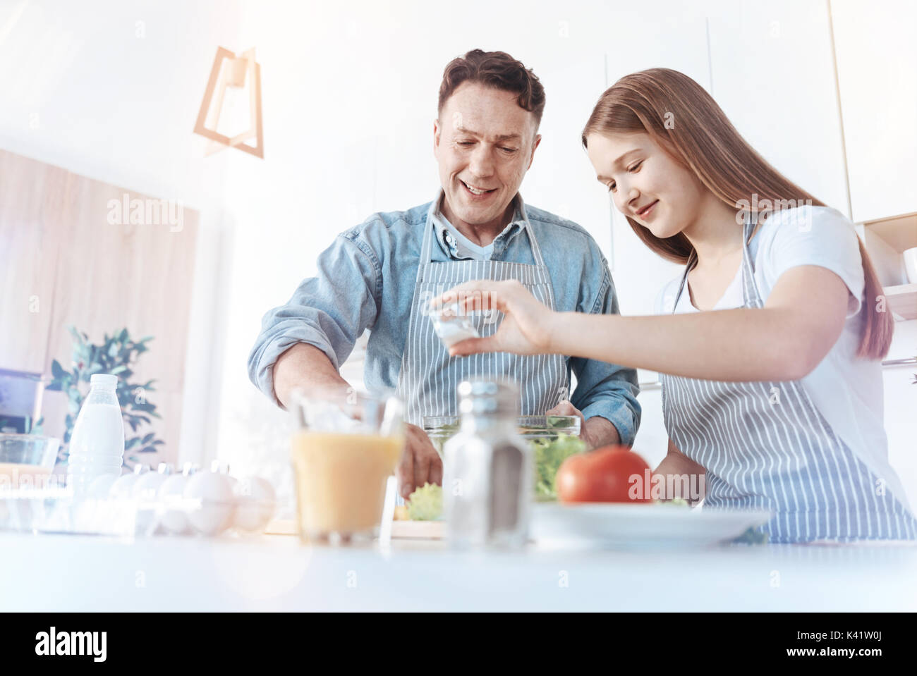 Positive dad and daughter during meal preparation Stock Photo - Alamy