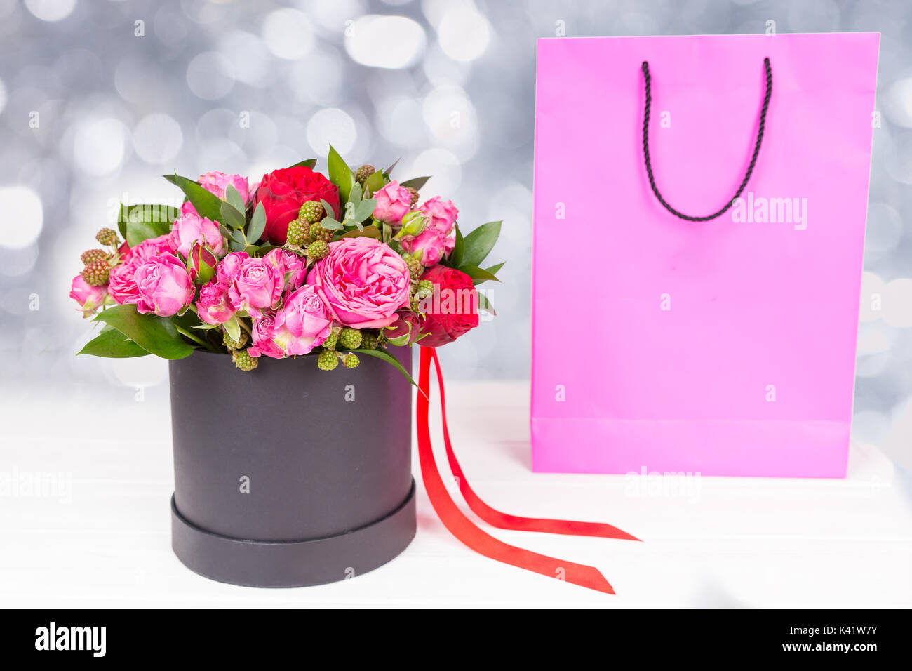 Lovely bouquet of pink and red roses and red ribbon in a circular black ...