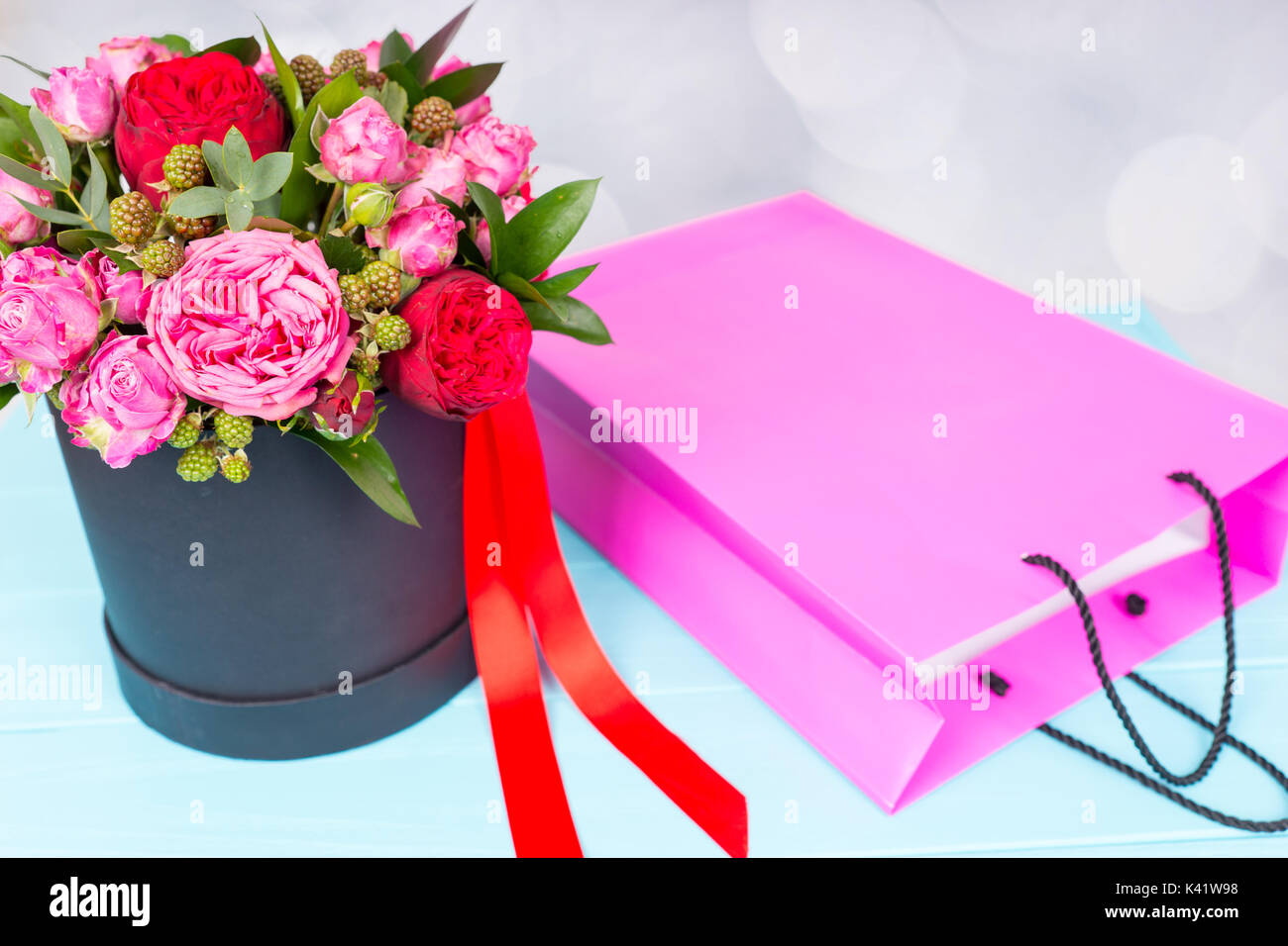 Stylish bouquet of pink and red roses and red ribbon in a circular ...