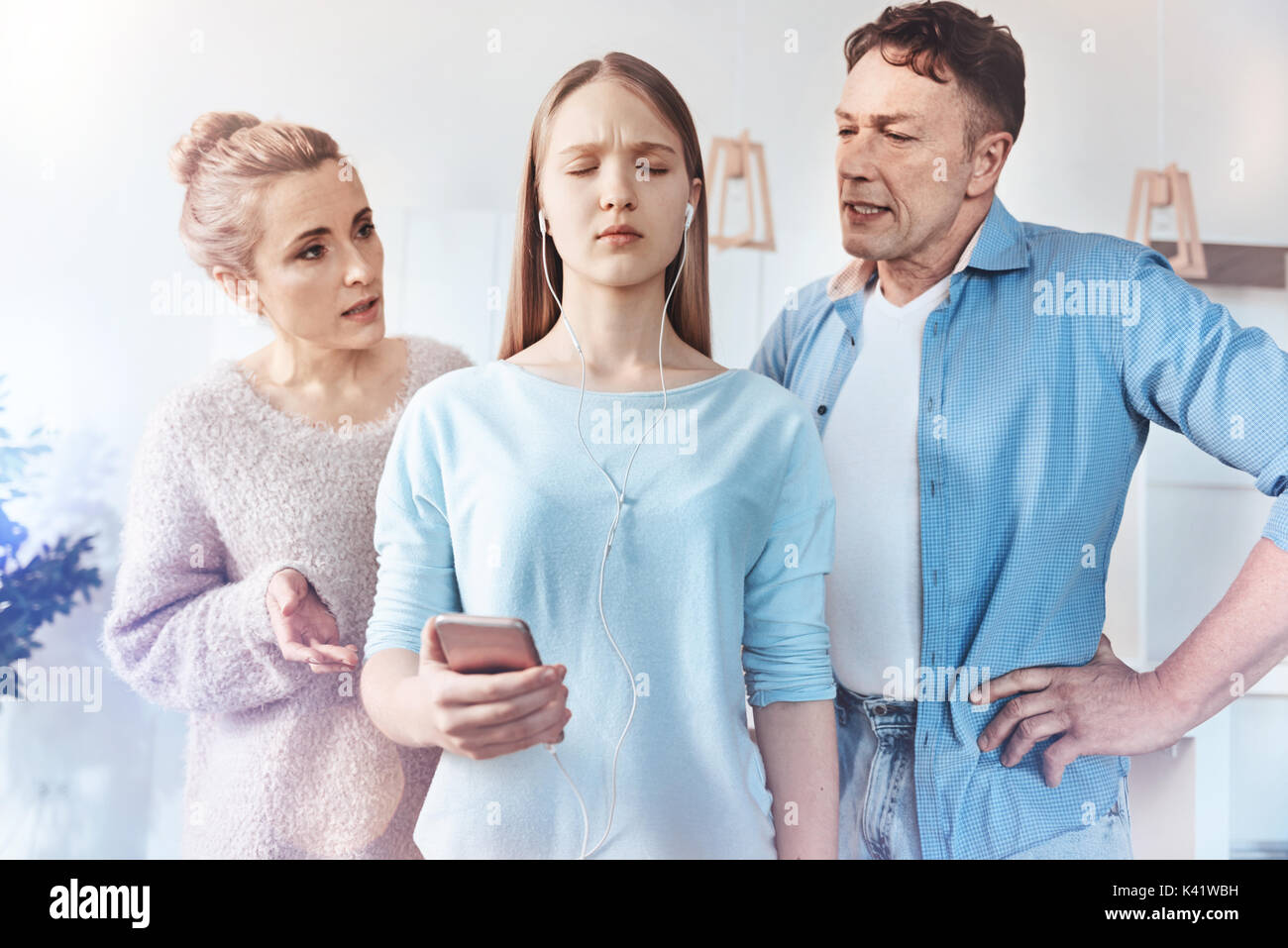 Teenage girl listening music refusing to listen her parents Stock Photo ...
