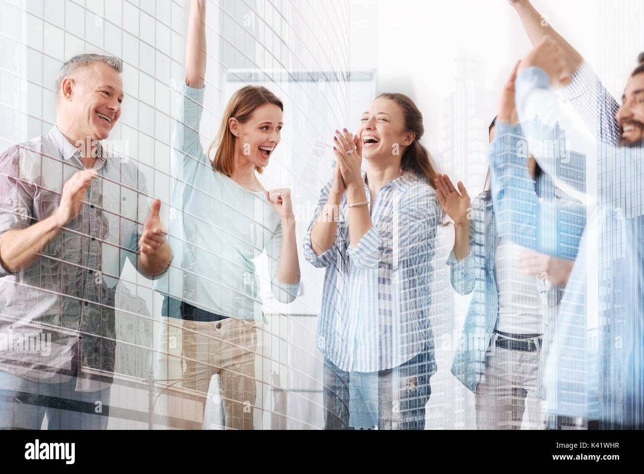 Elated cheerful colleagues standing in the office Stock Photo - Alamy