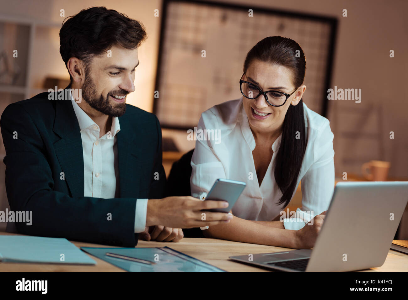 Handsome male person showing his telephone to colleague Stock Photo - Alamy