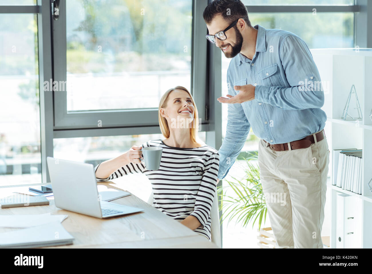 Cheerful office workers socializing during a break Stock Photo - Alamy