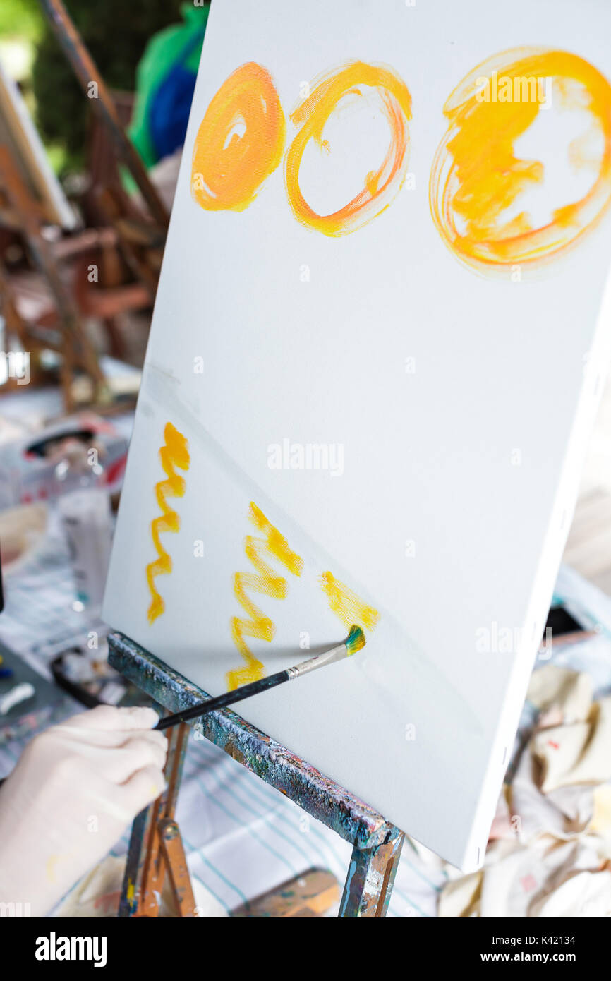 artist's hand with brush painting on canvas Stock Photo - Alamy
