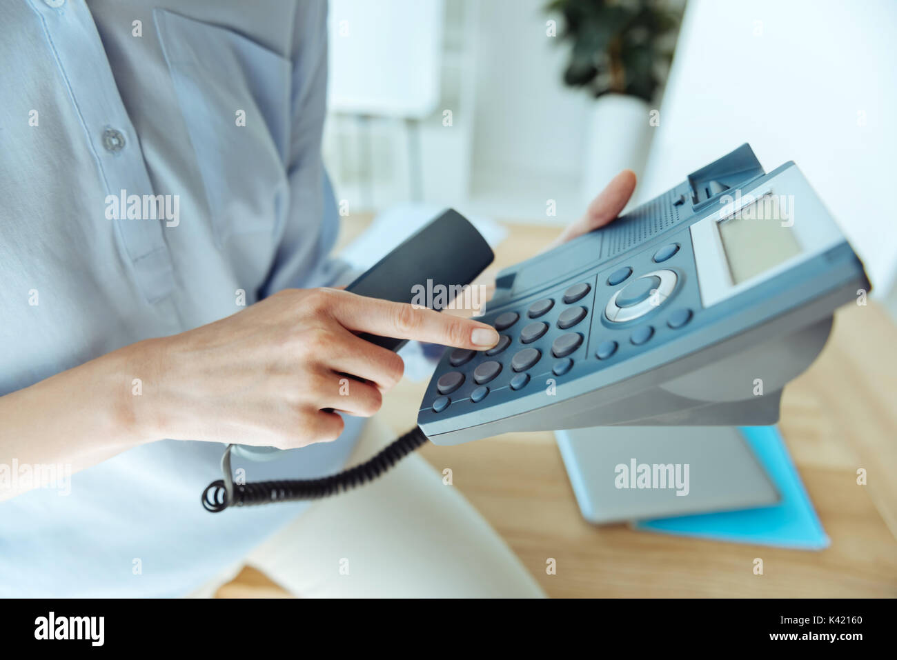 Female hands pressing a button on landline phone Stock Photo - Alamy