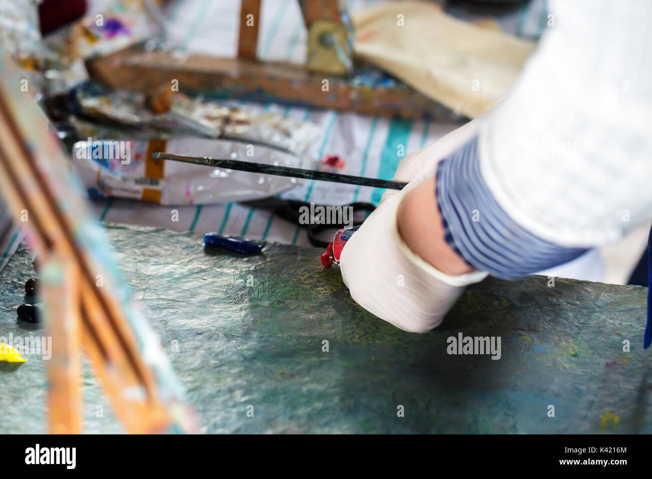 artist holding a tube with oil paints Stock Photo - Alamy