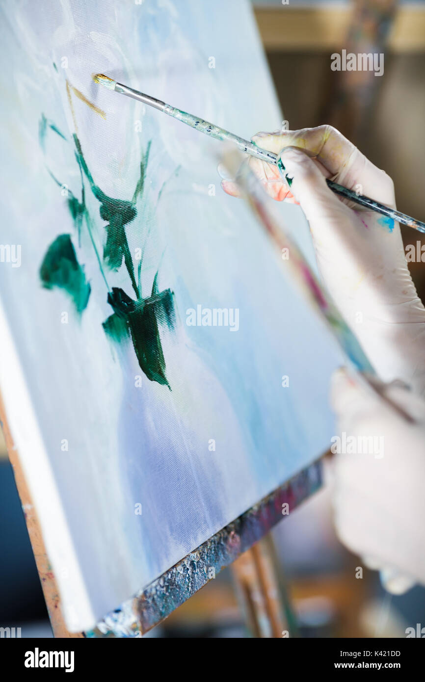 hand of artist with brush painting on canvas Stock Photo - Alamy