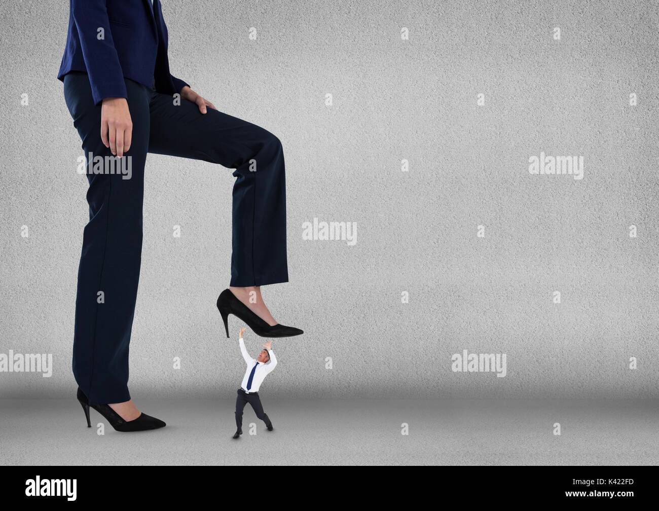 Digital composite of Big business woman trying to step on a small ...
