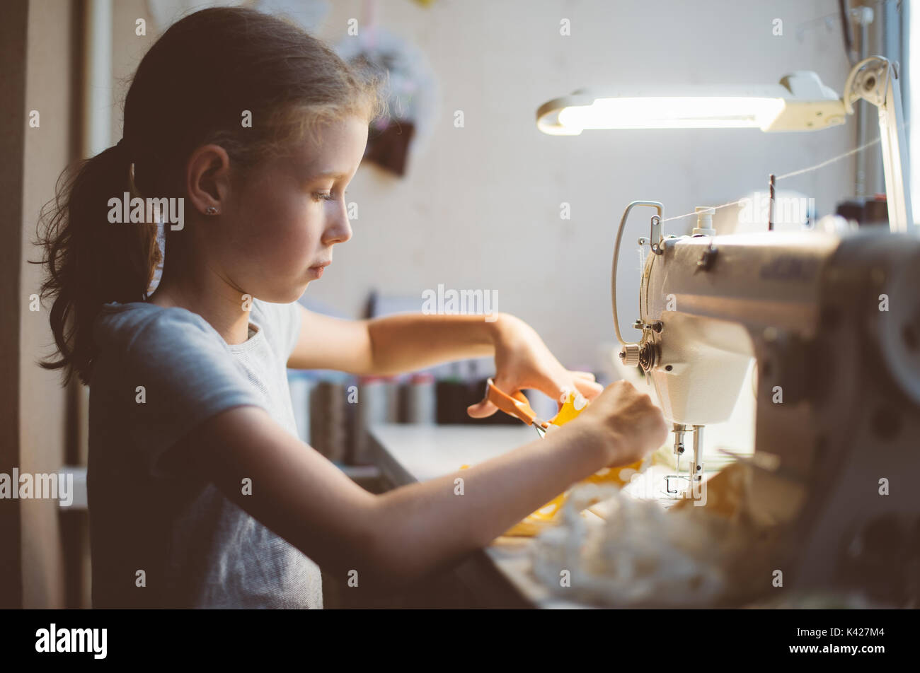Little girl working on sewing machine at home Stock Photo - Alamy