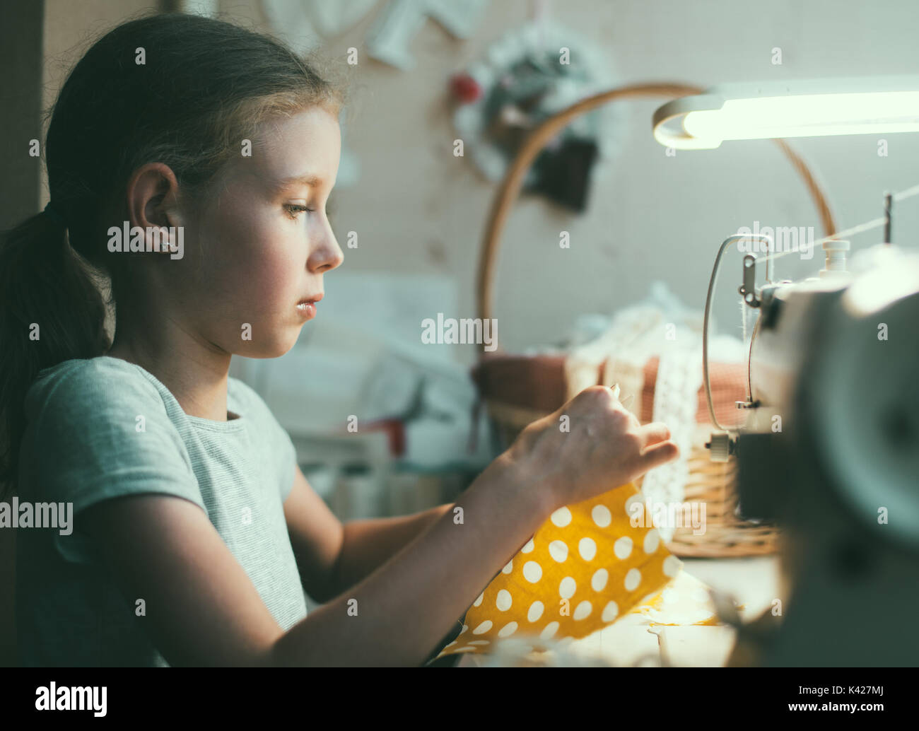 Little girl working on sewing machine at home Stock Photo - Alamy