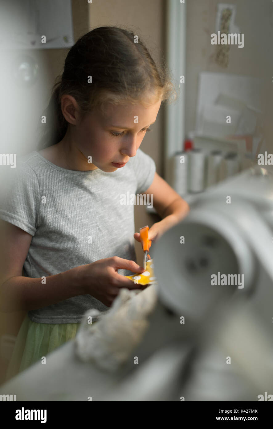 Little girl working on sewing machine at home Stock Photo - Alamy