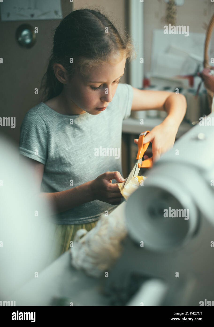 Little girl working on sewing machine at home Stock Photo - Alamy