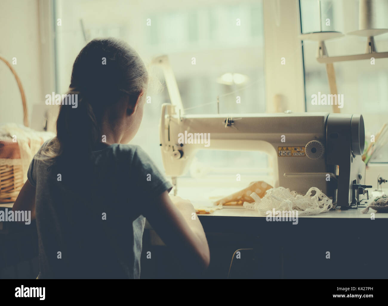 Little girl working on sewing machine at home Stock Photo - Alamy