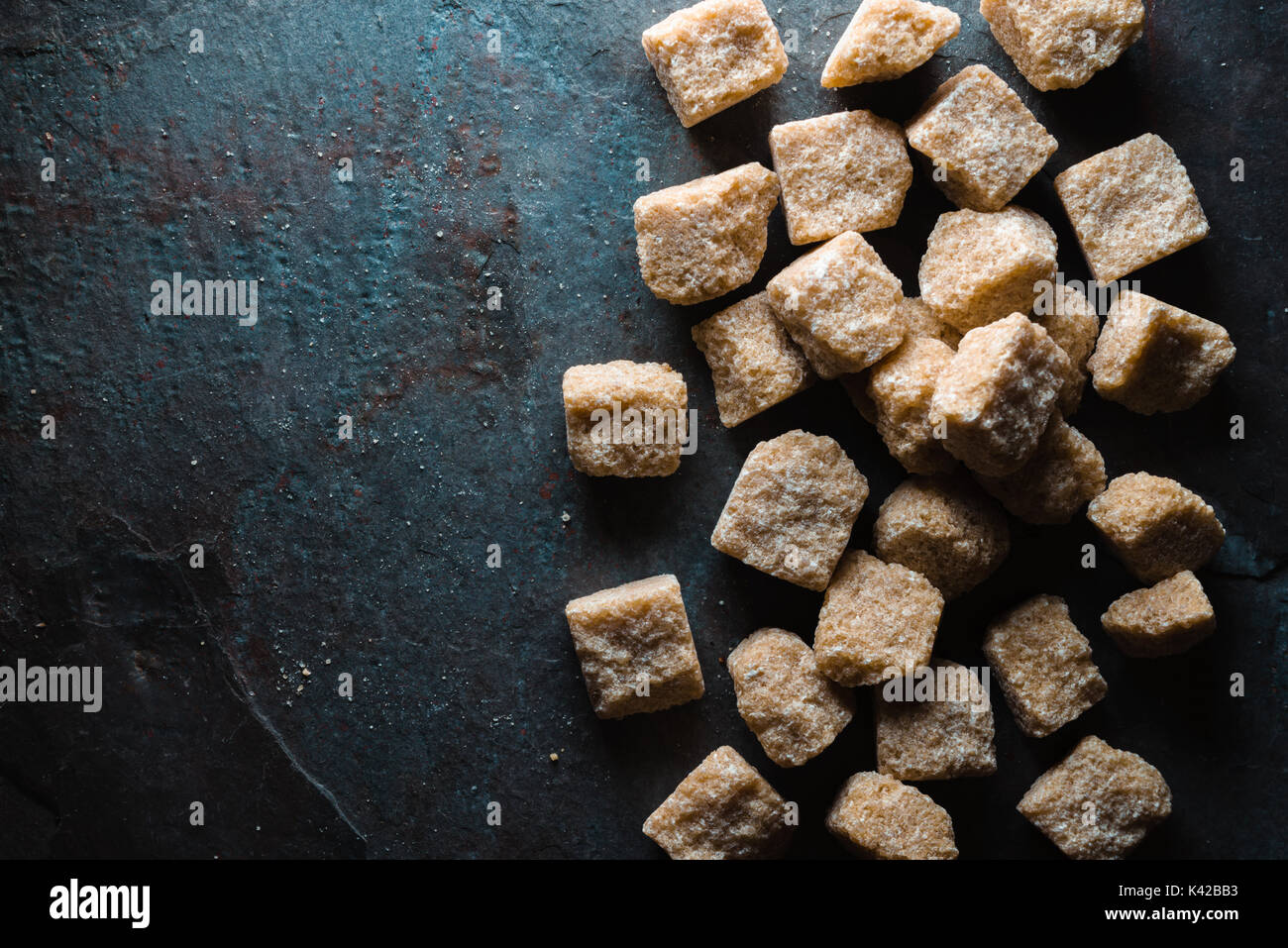 Cubes of cane sugar on a blue stone on the right horizontal Stock Photo ...