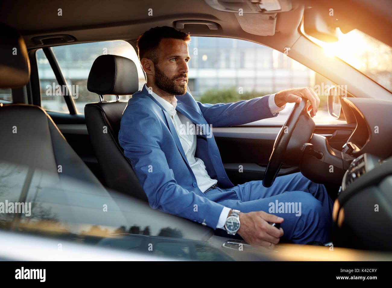 Attractive elegant man in business suit driving car Stock Photo - Alamy