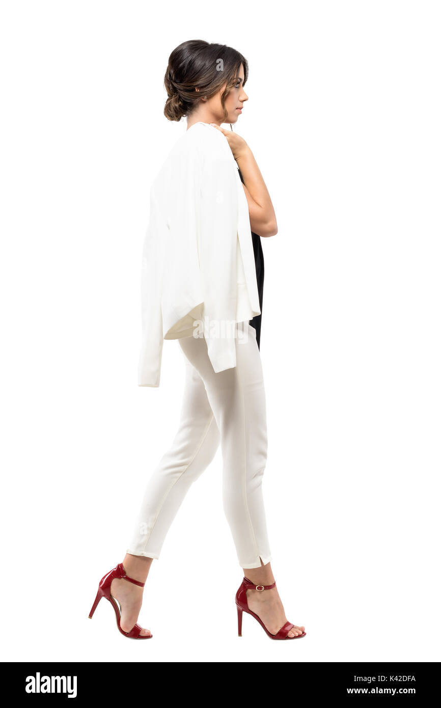 Stylish business woman in white suit walking and carrying jacket over ...