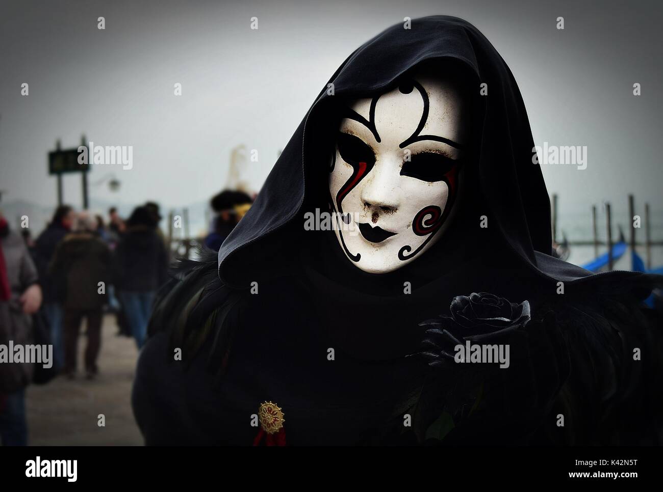 A Venetian masquerade in costume with a sad mask at the carnival of ...