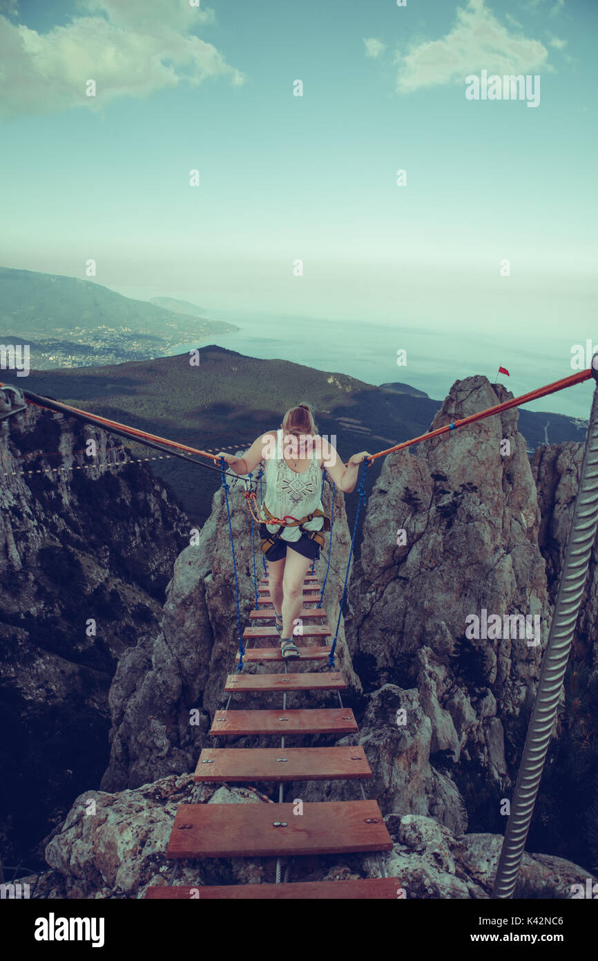 Woman is walking along a suspension bridge over an abyss. Yalta, the ...
