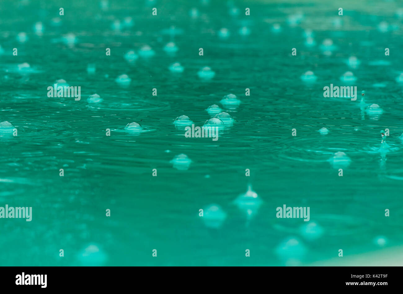 Raindrops falling in blue swimming pool Stock Photo - Alamy