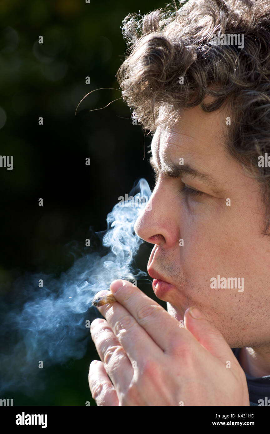 Middle aged man smoking a roll up Stock Photo - Alamy