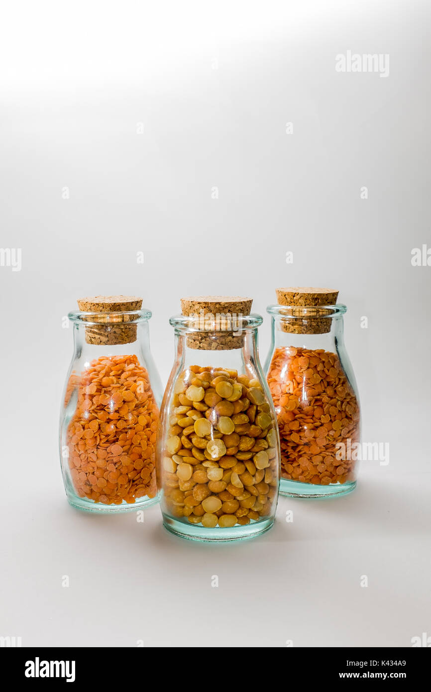 Three small glass jars filled with pulses on a neutral background Stock ...