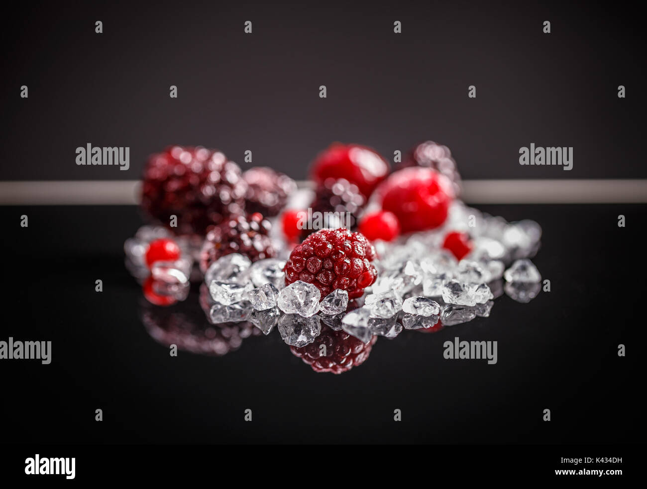 Frozen mixed red berry fruits on crushed ice Stock Photo - Alamy
